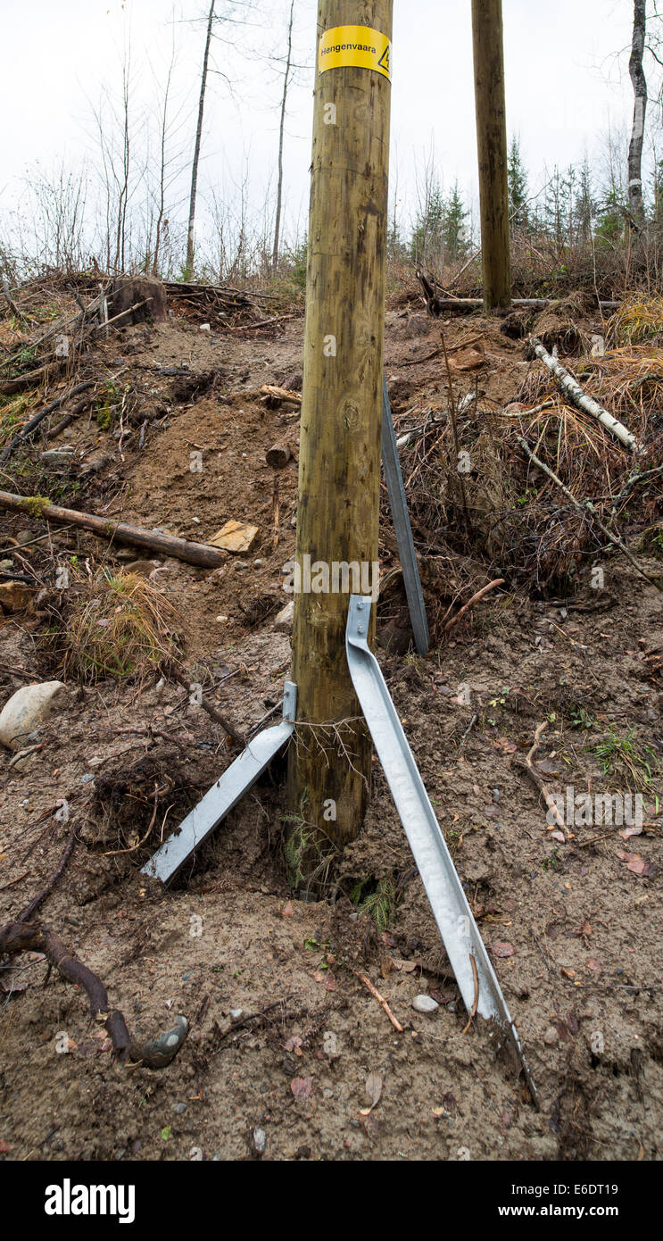 Power line pylon supported by metal struts on unstable muddy soil ...