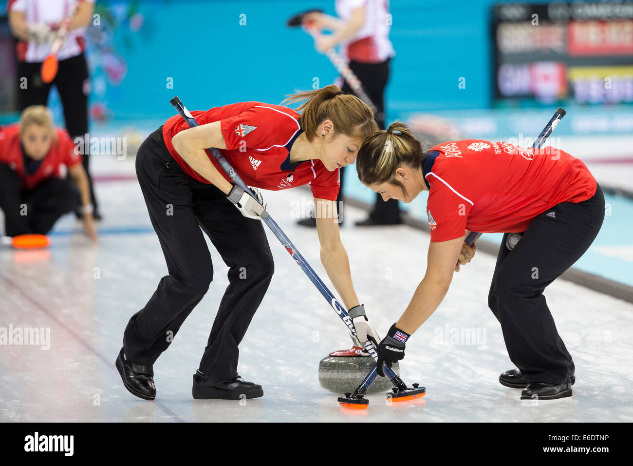 Anna Sloan (C) of Team Great Britain plays a stone with Claire Hamilton ...