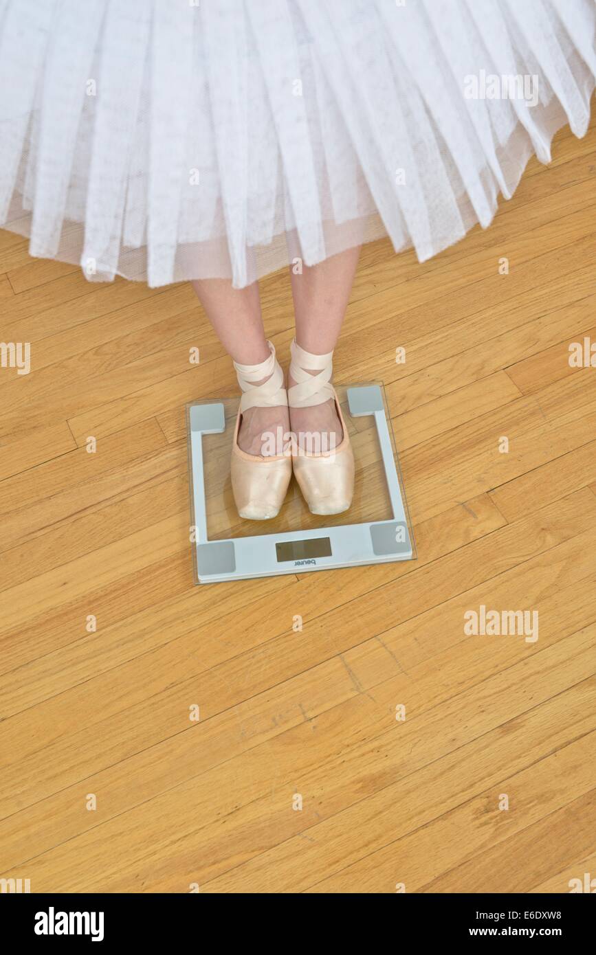 Teen with pointe ballet shoes standing on weight scale Stock Photo - Alamy