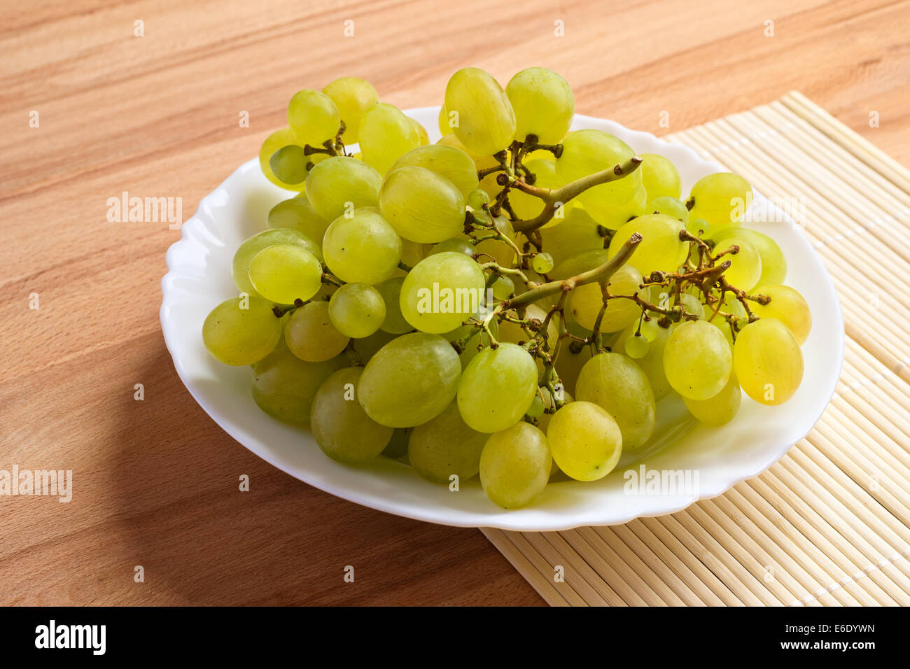 Delicious fresh grapes in white plate on wood background Stock Photo ...