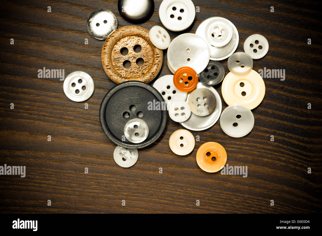 old clothing buttons, dark wood background Stock Photo - Alamy