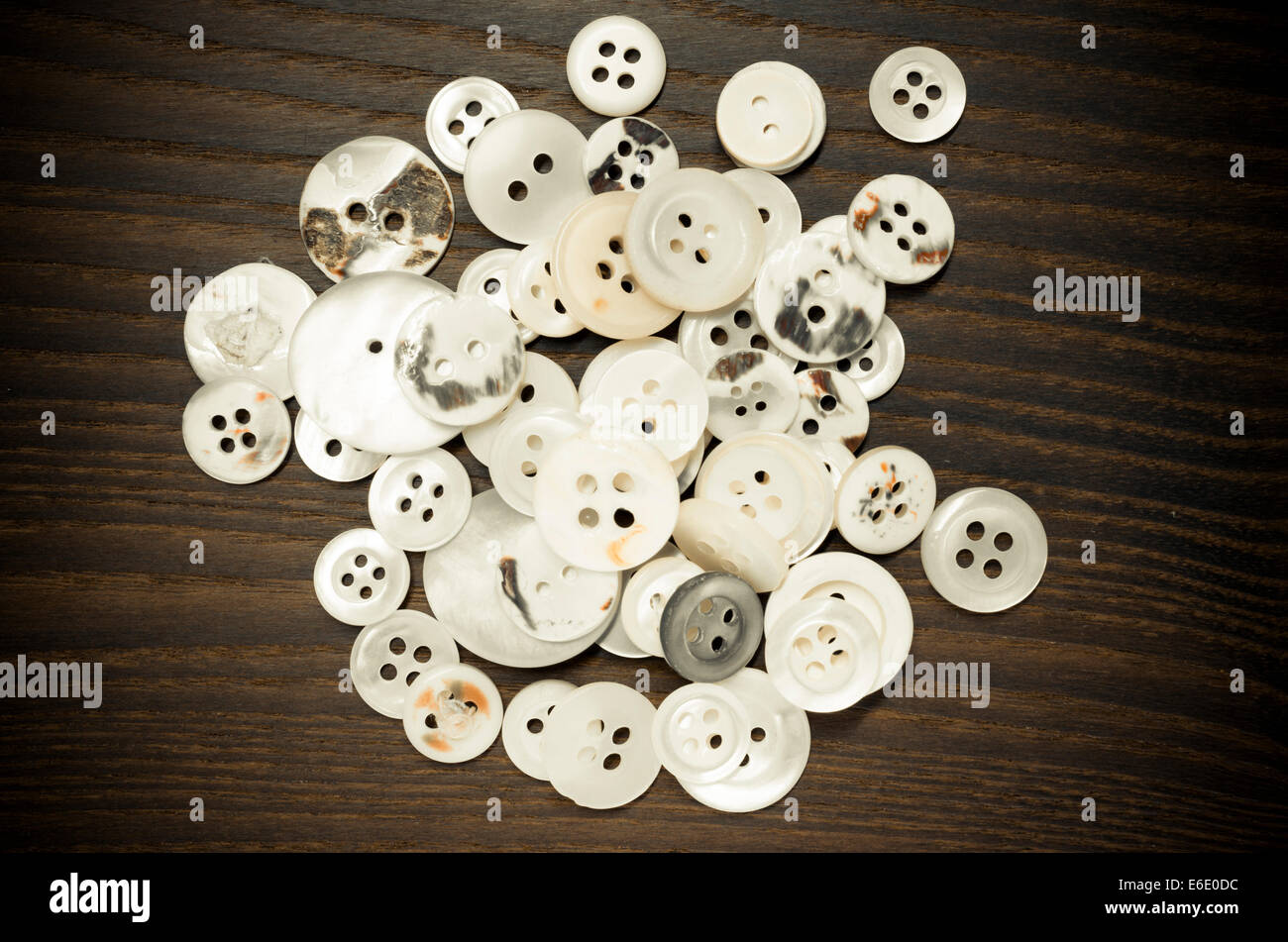 old clothing buttons, dark wood background Stock Photo - Alamy