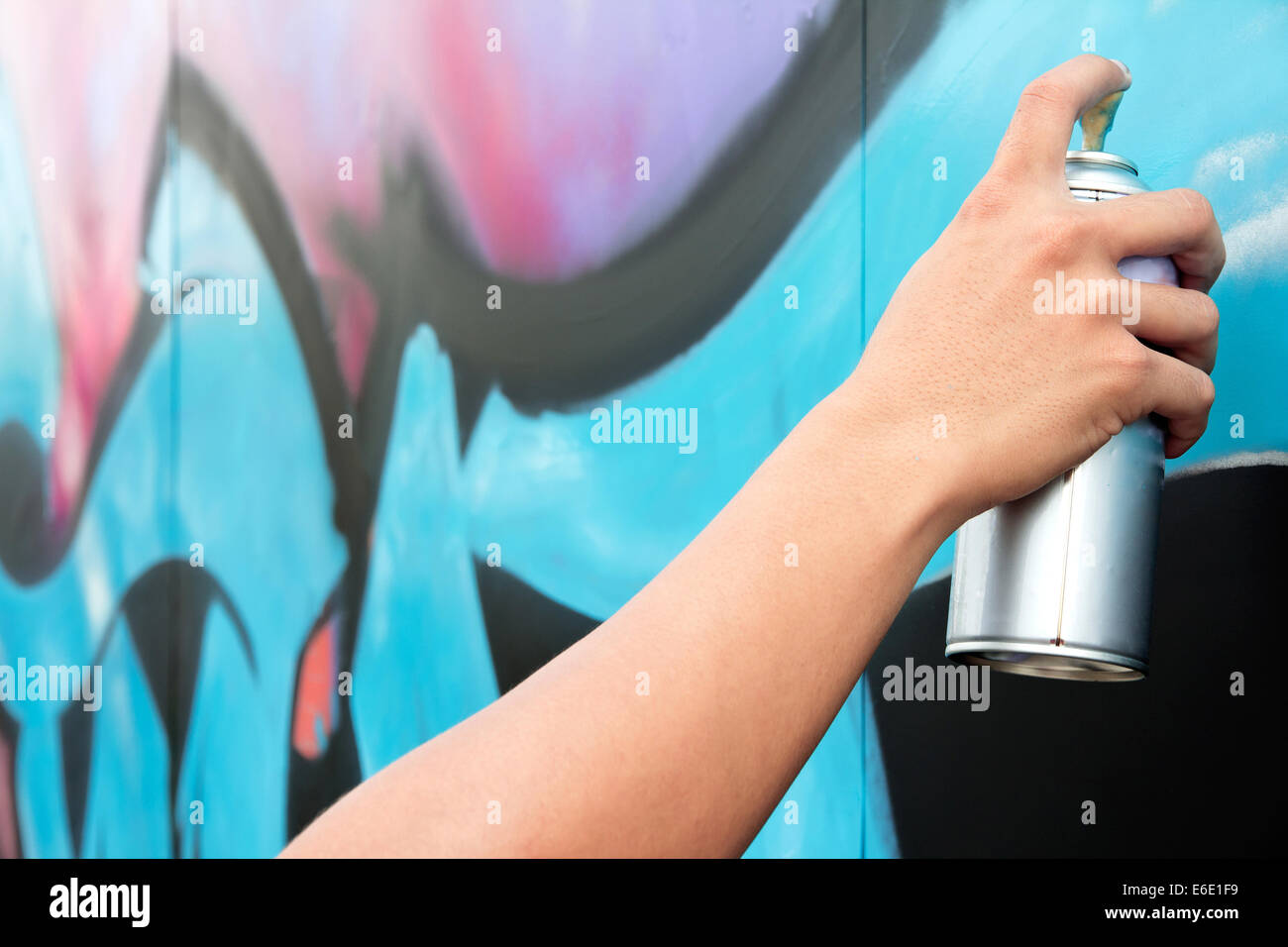Graffiti artist spraying the wall Stock Photo - Alamy