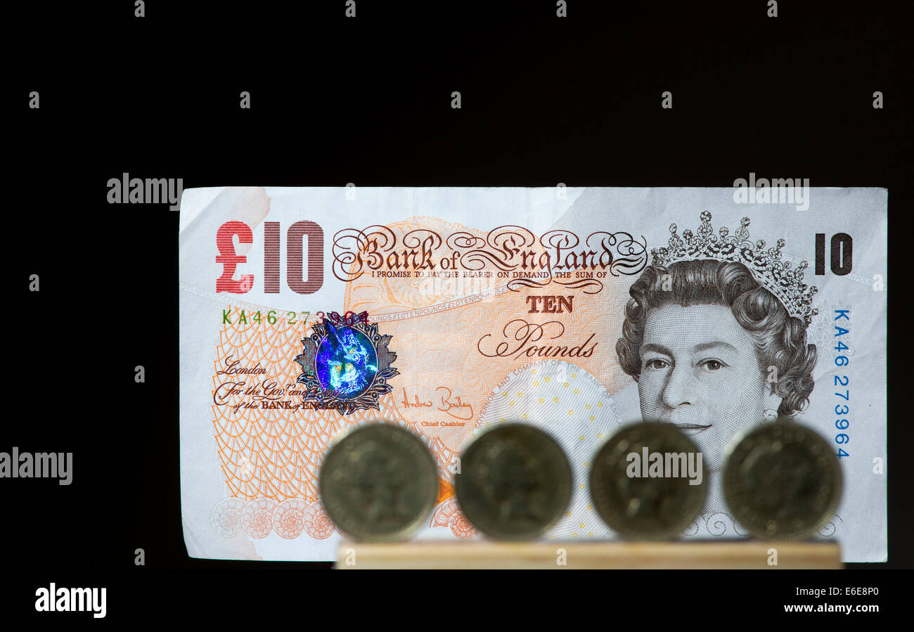 £1 British Stirling coins are pictured in front of a £10 British ...