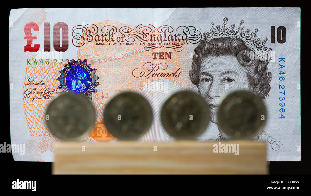 £1 British Stirling coins are pictured in front of a £10 British ...