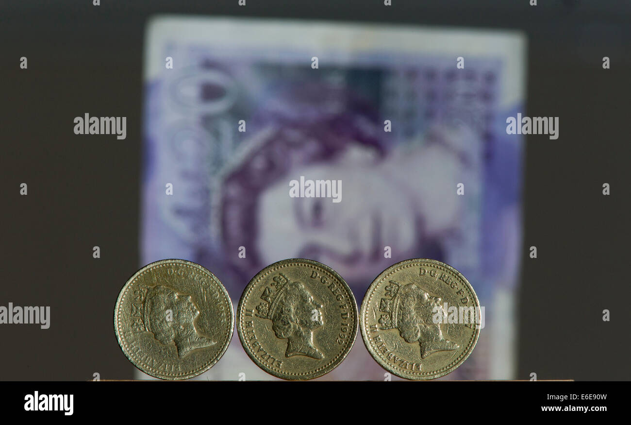 £1 British Stirling coins are pictured in front of a £20 British ...