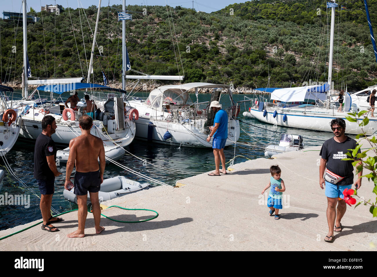 People walk at the port of Steni Vala village in Alonnisos, Greece on ...