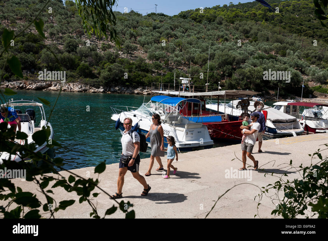 People walk at the port of Steni Vala village in Alonnisos, Greece on ...