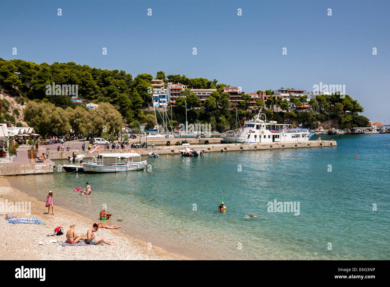 People swim at a beach next to the port of Patitiri in Alonissos on ...