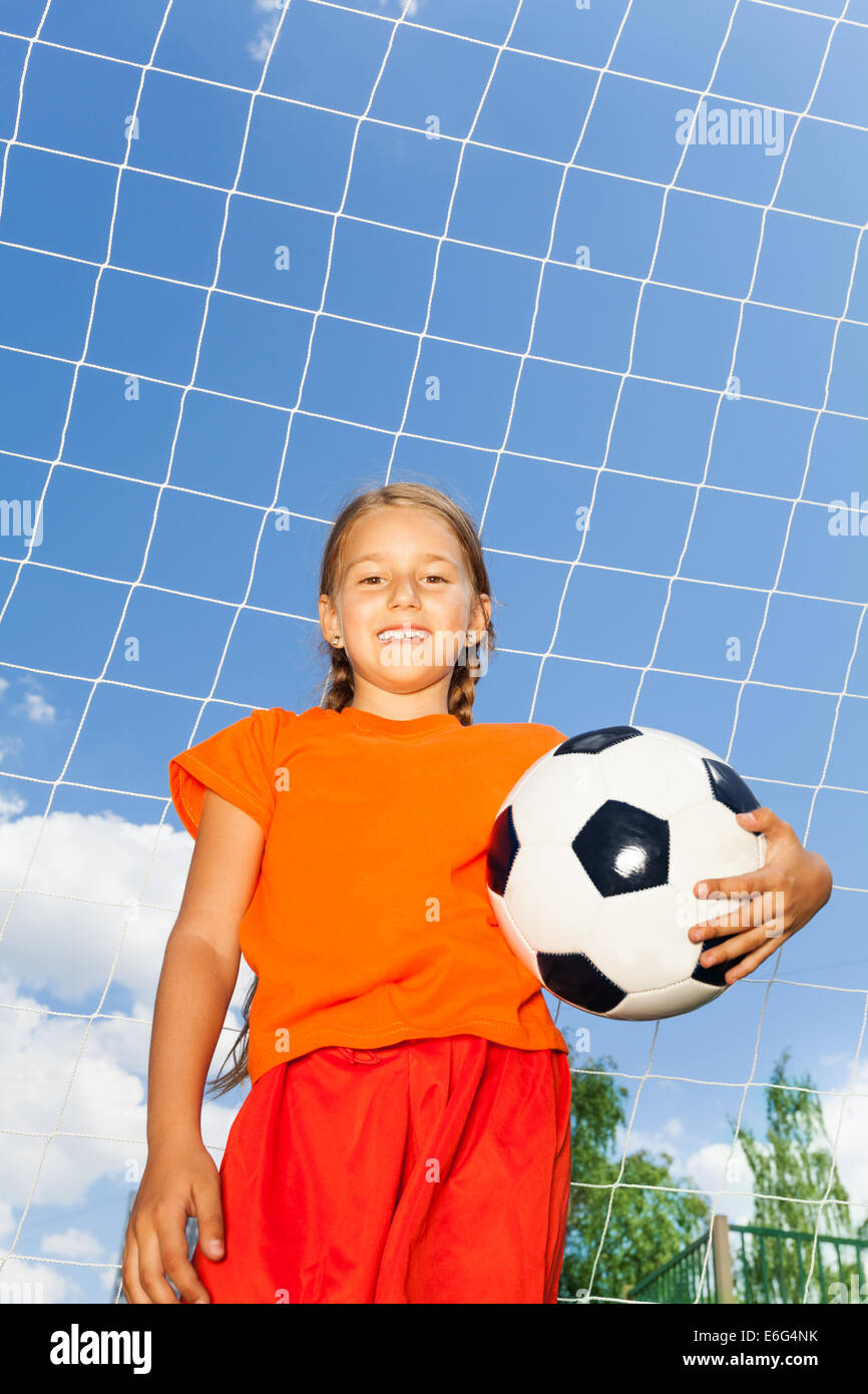 Girl holding football in one arm standing Stock Photo - Alamy