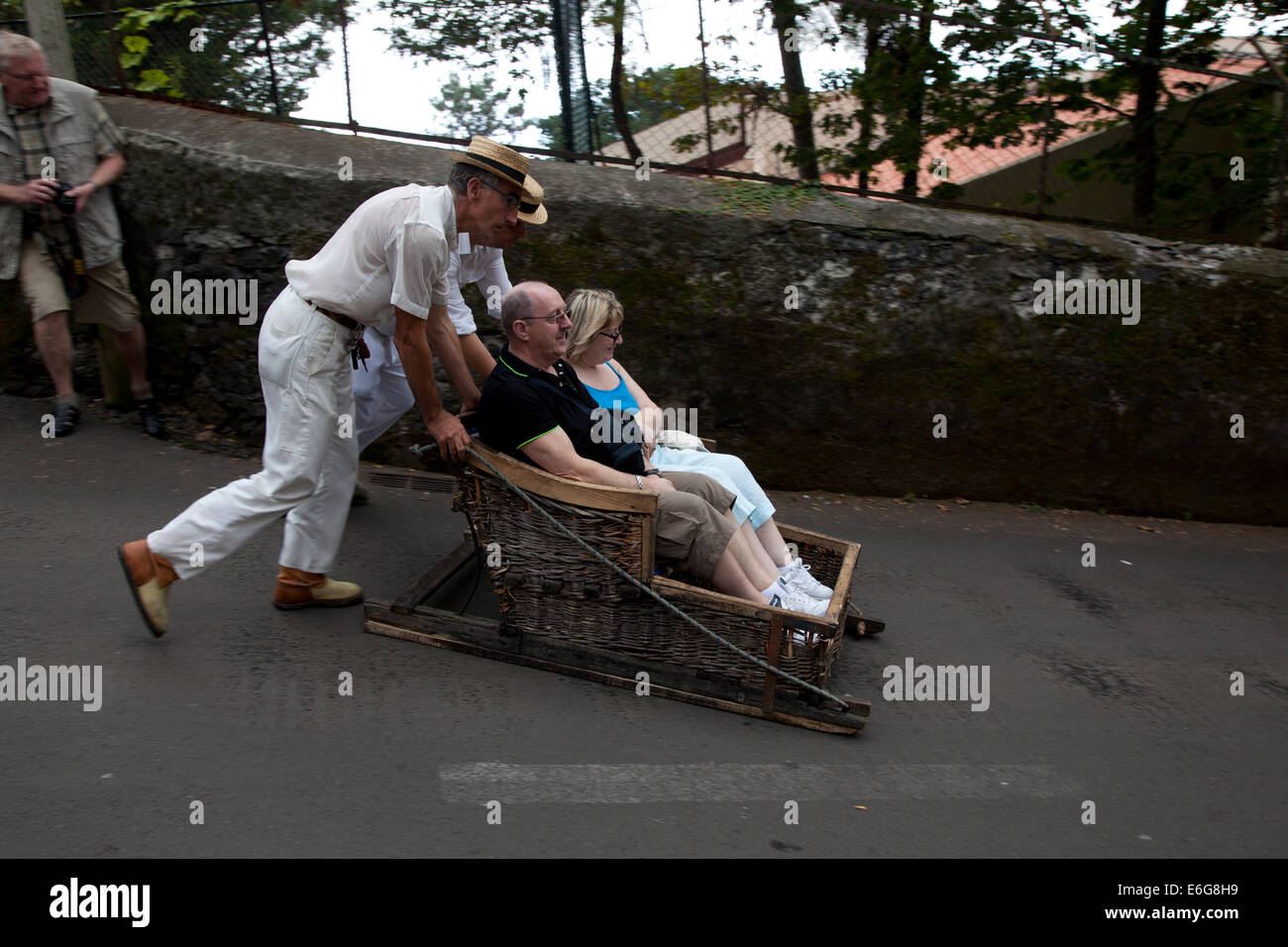 People riding sled in madeira Stock Photo - Alamy