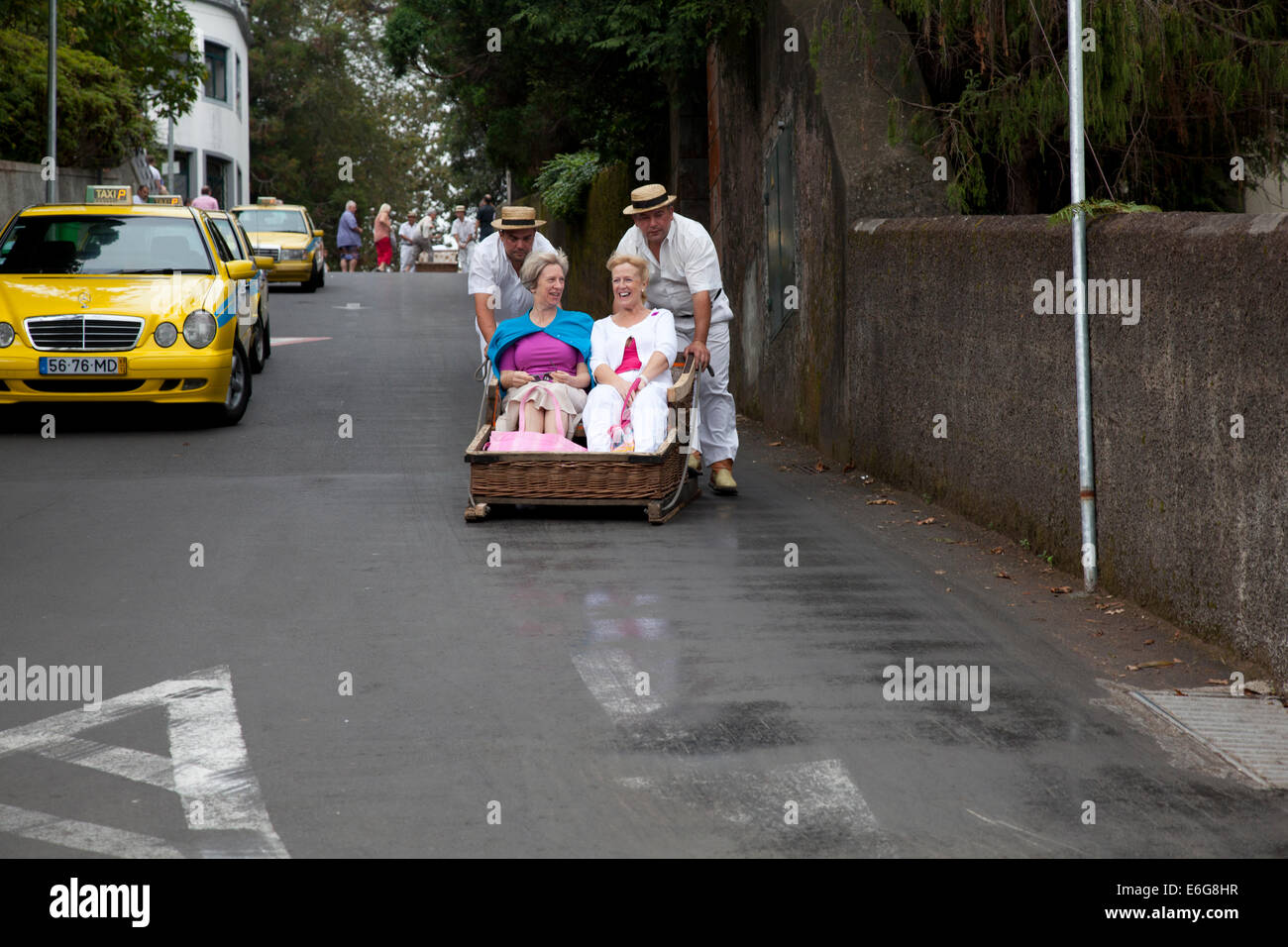 People riding sled in madeira Stock Photo - Alamy