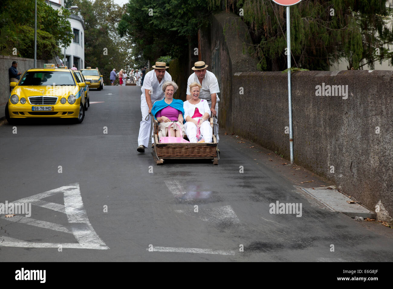People riding sled in madeira Stock Photo - Alamy
