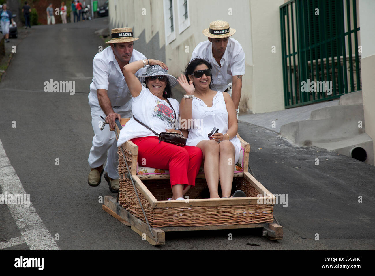 People riding sled in madeira Stock Photo - Alamy