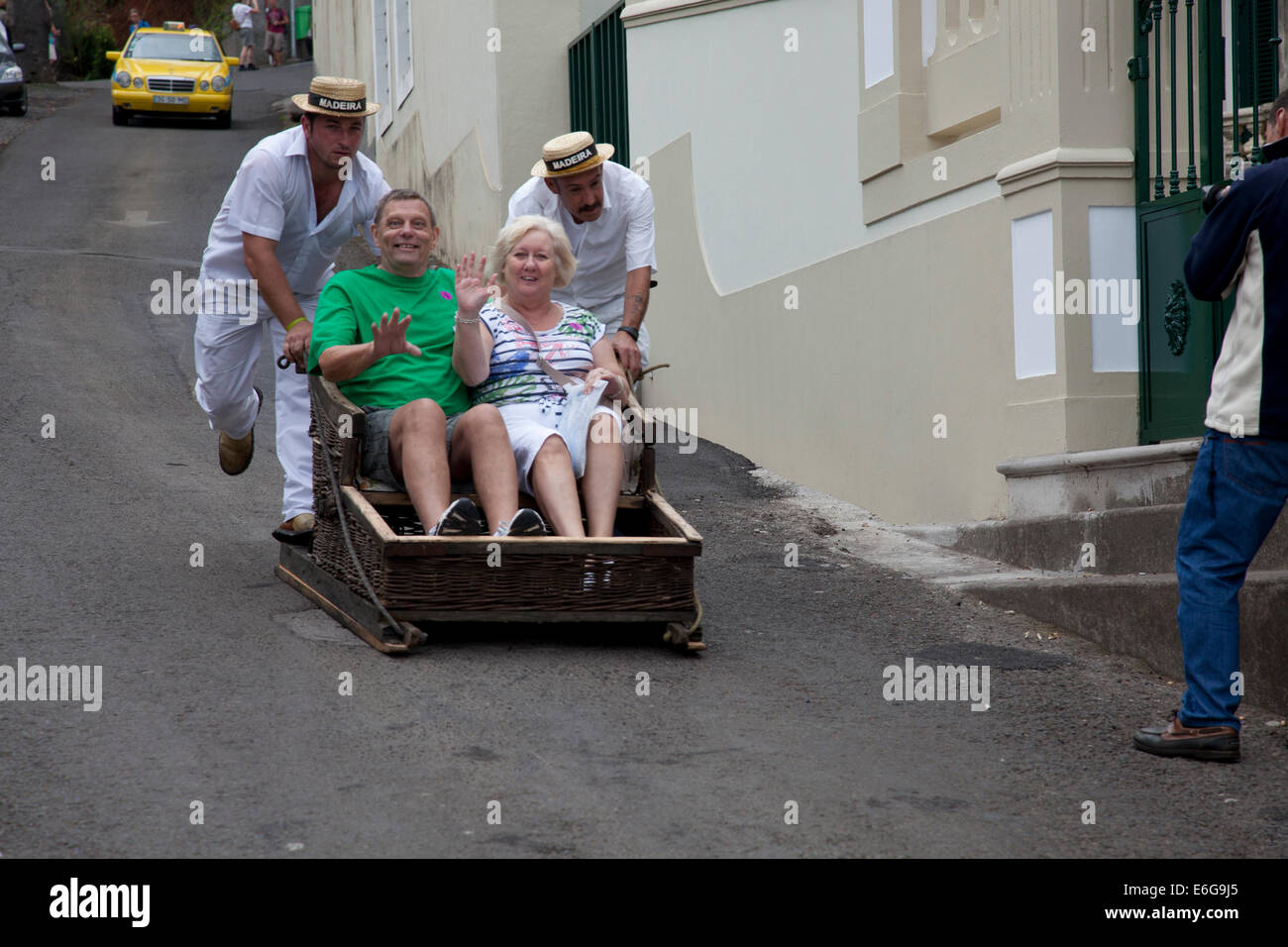 People riding sled in madeira Stock Photo - Alamy