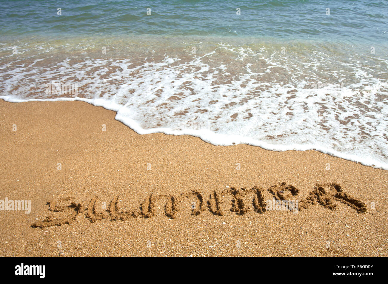 "Summer" ; written in the sand on the beach with blue waves in the ...