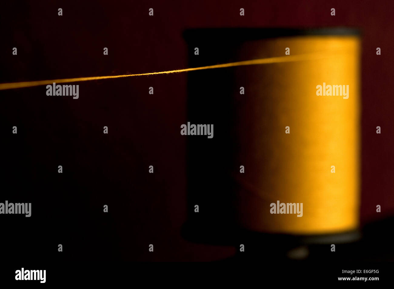 Yellow spool of thread Stock Photo - Alamy