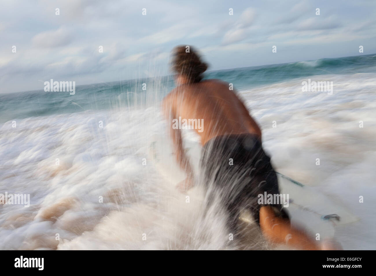 Surfer running into water at Sandy Beach Stock Photo - Alamy