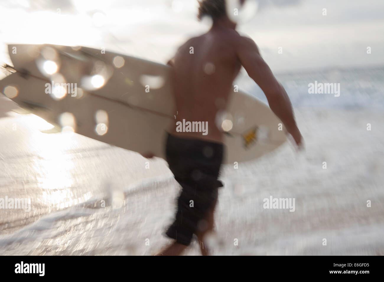 Surfer running into water at Sandy Beach Stock Photo - Alamy