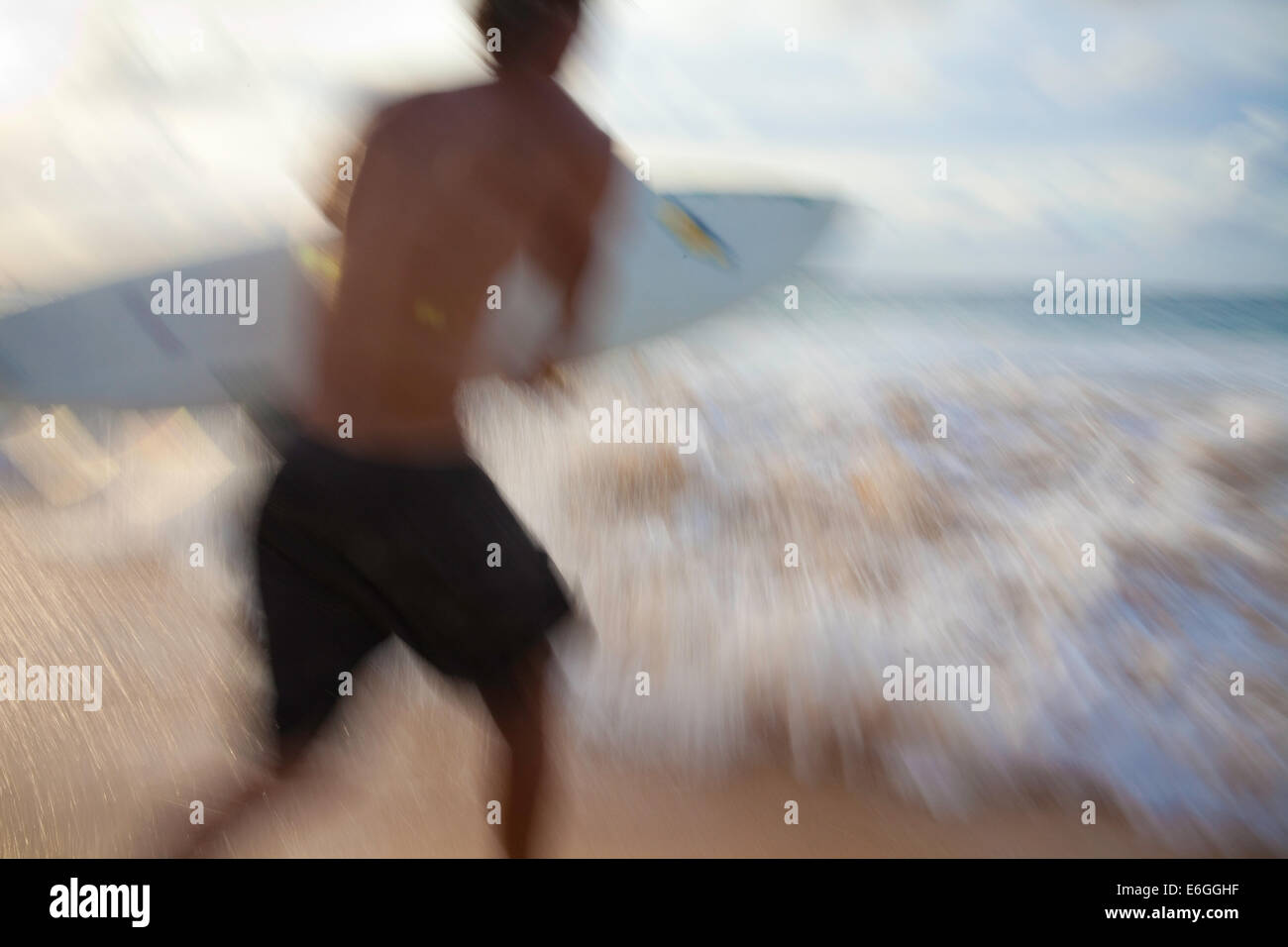 Surfer running into water at Sandy Beach Stock Photo - Alamy