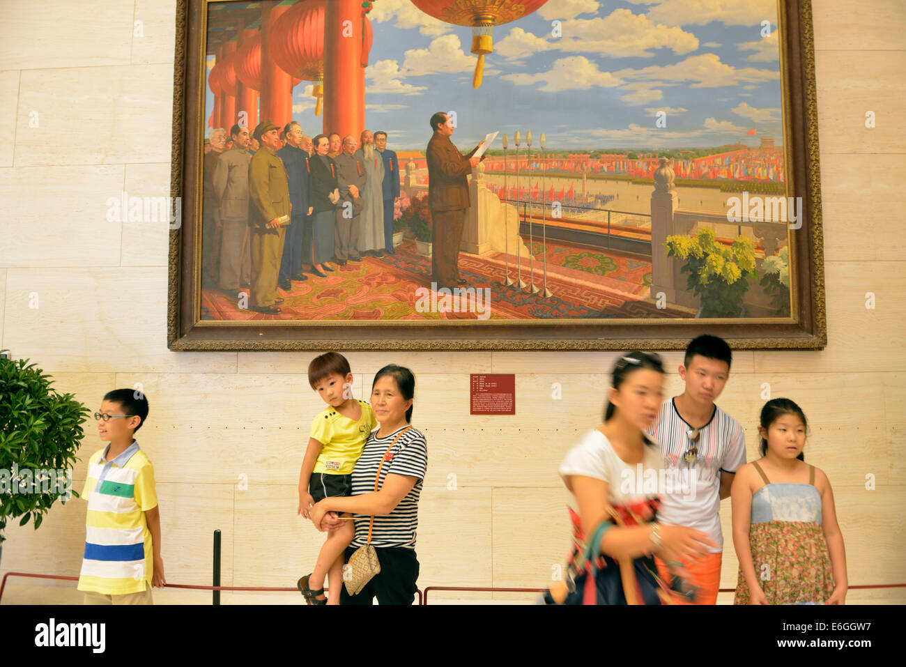 People stand in front of a painting named Founding Ceremony of State ...