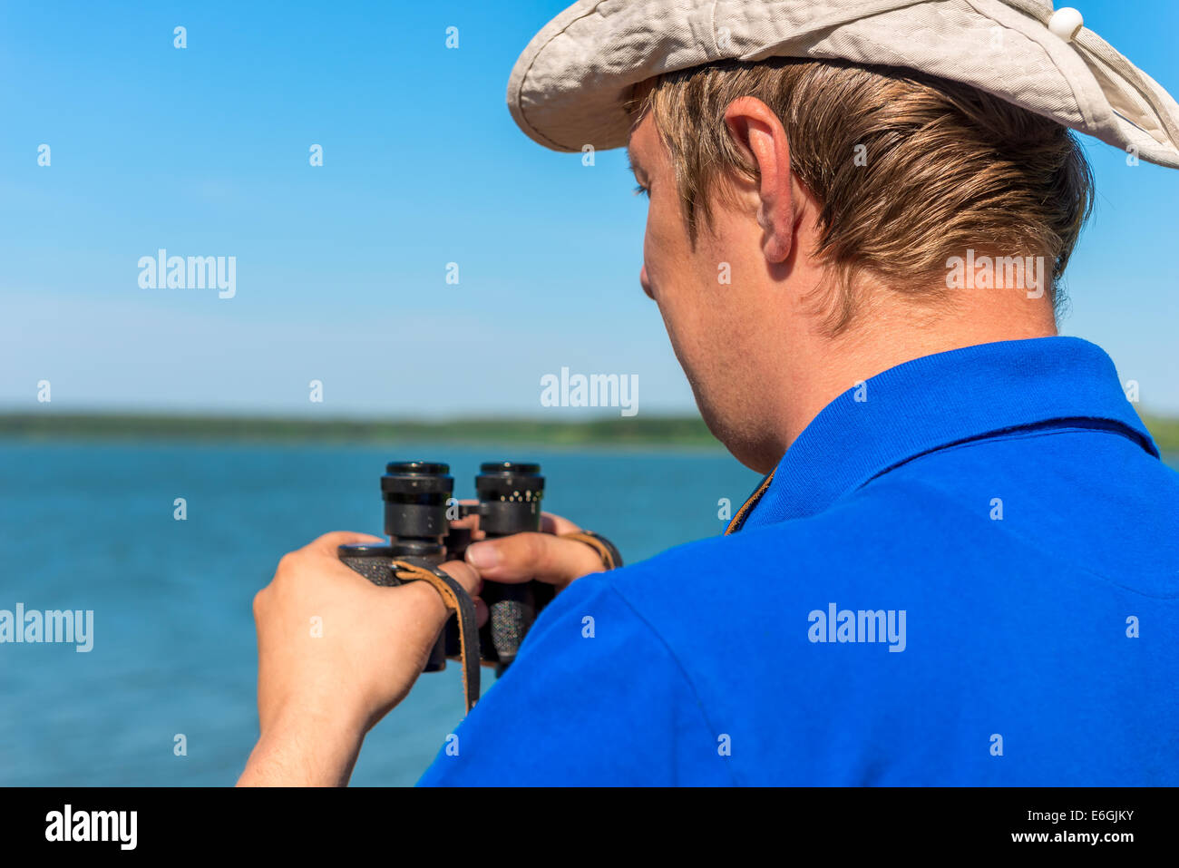 a young man with binoculars on the nature Stock Photo - Alamy