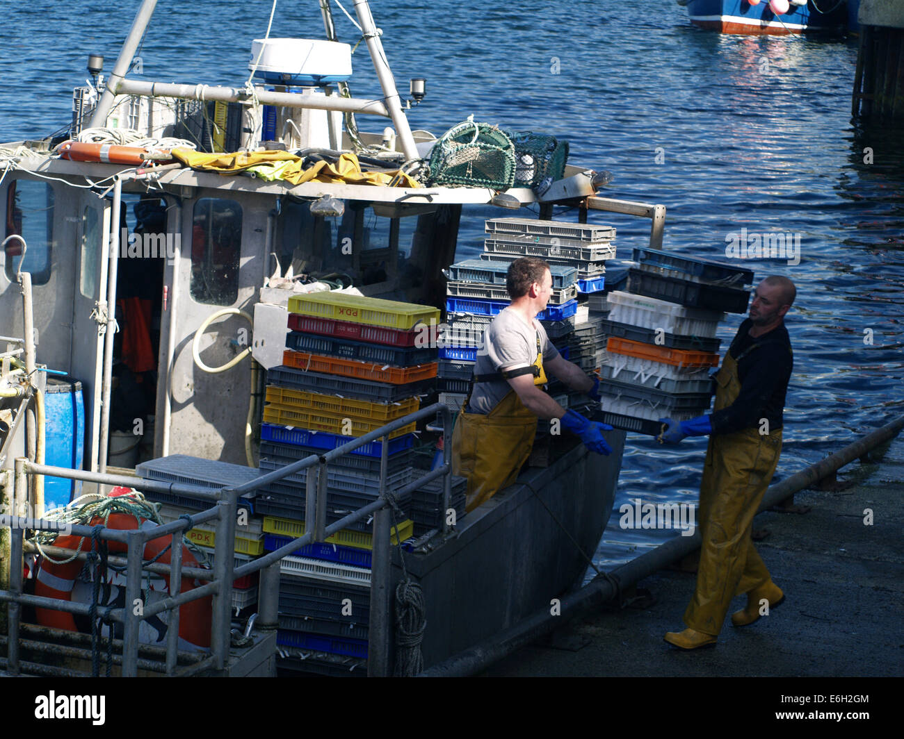 Two fishermen preparing and loading their fishing boat to catch ...