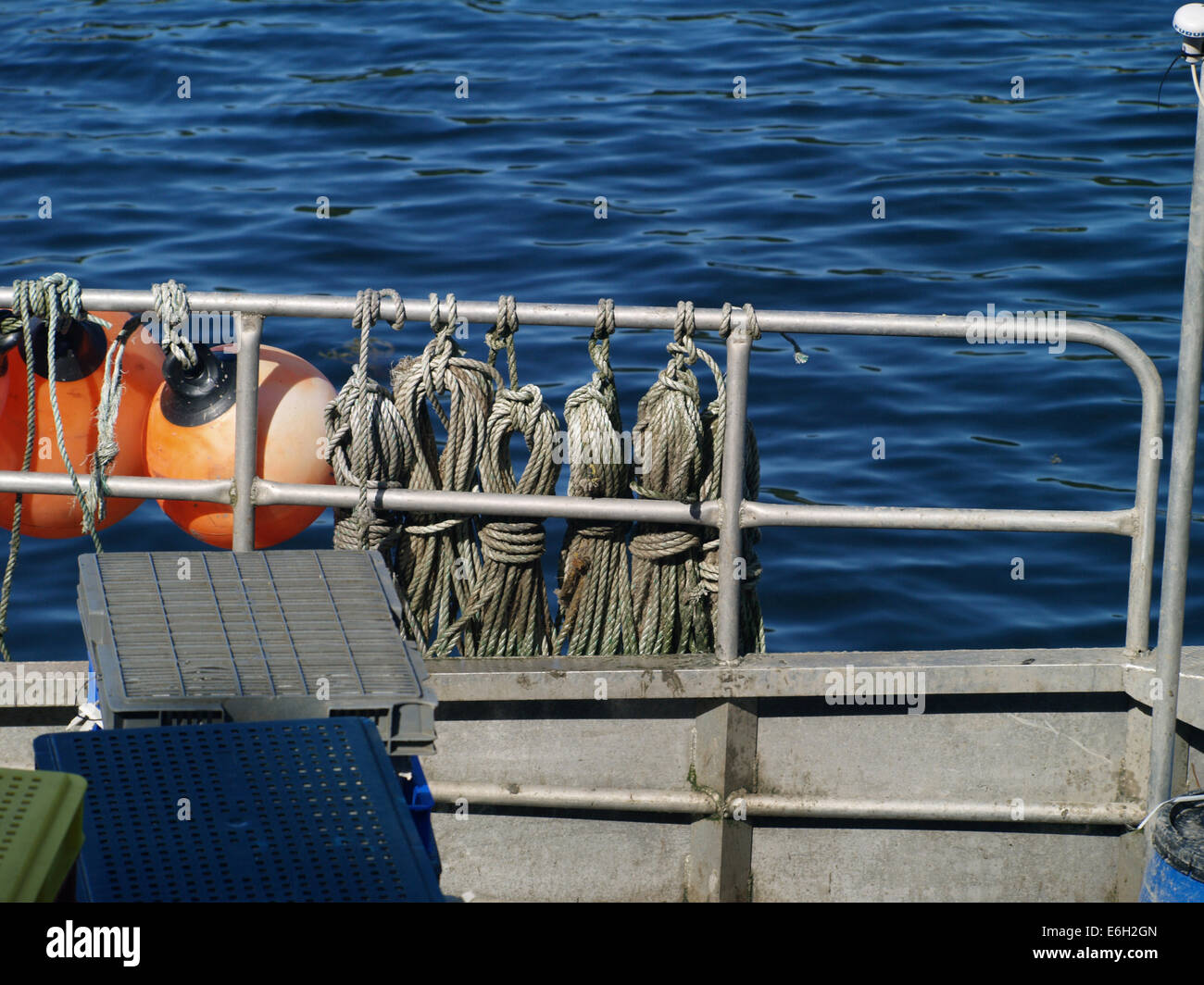 Railings of a fishing boat with a line of knotted ropes and buoys ...