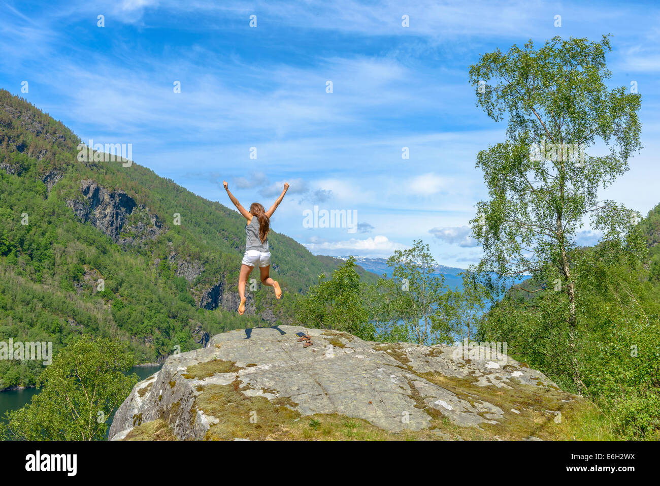 Woman jumping high at a cliff representing winning and victory Stock ...
