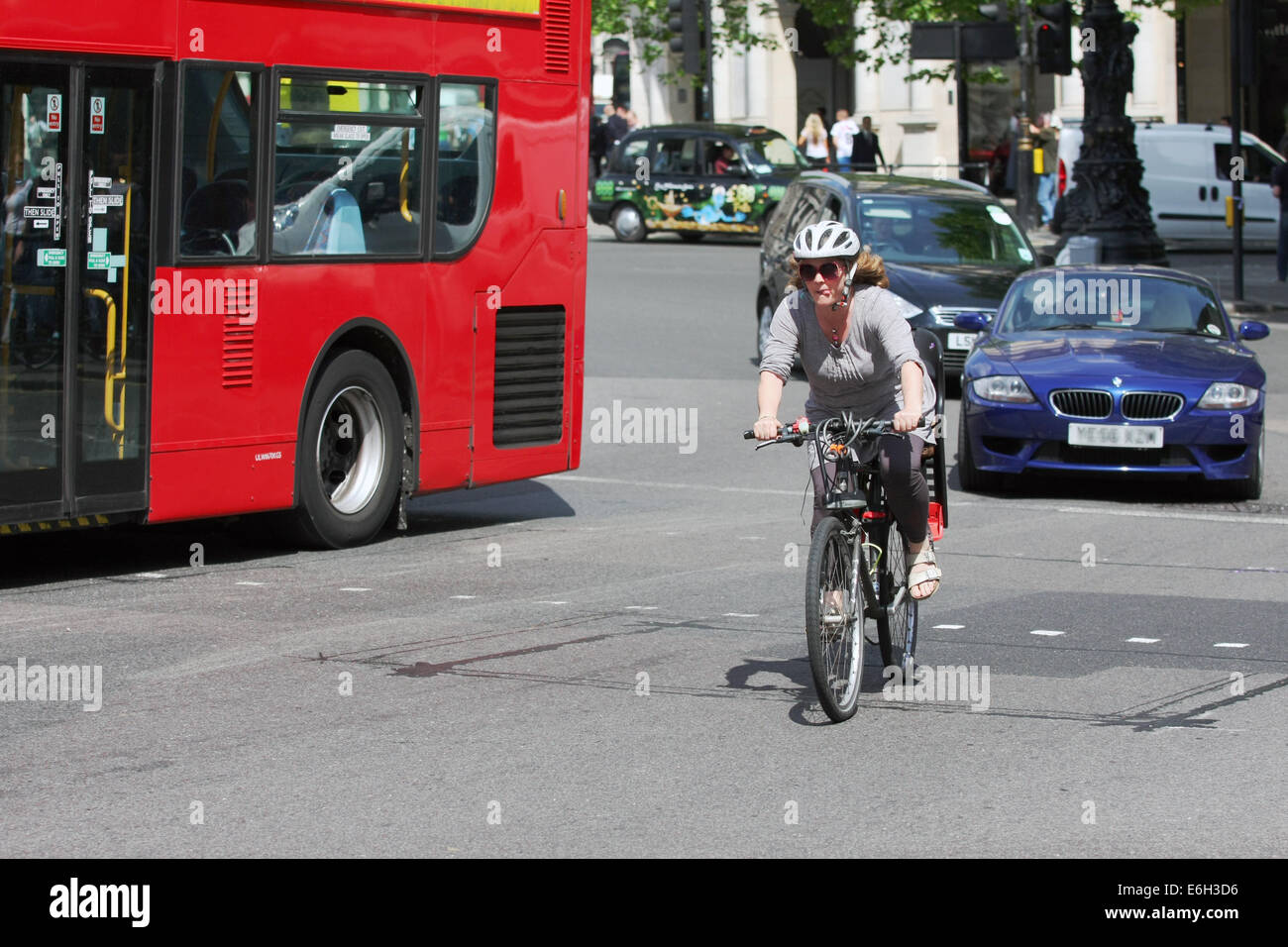 A cyclist riding a bicycle in traffic, in London Stock Photo - Alamy