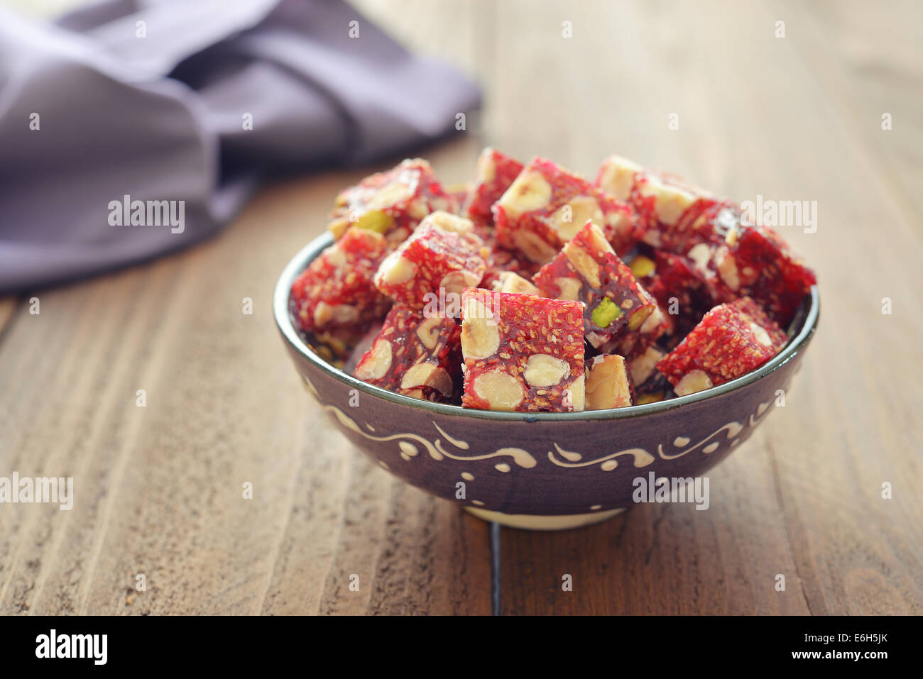 Turkish delight with nuts and sesame in ceramic bowl on wooden ...