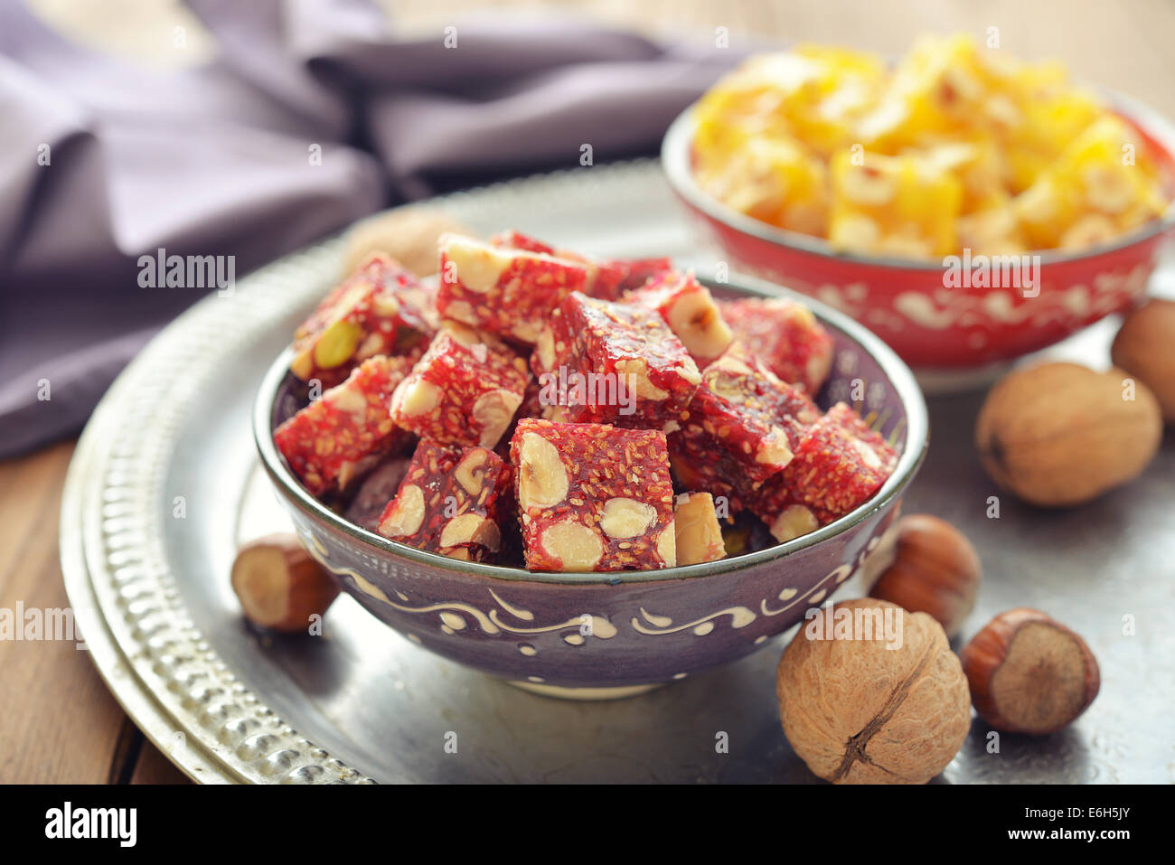 Turkish delight with nuts and sesame in ceramic bowl on wooden ...