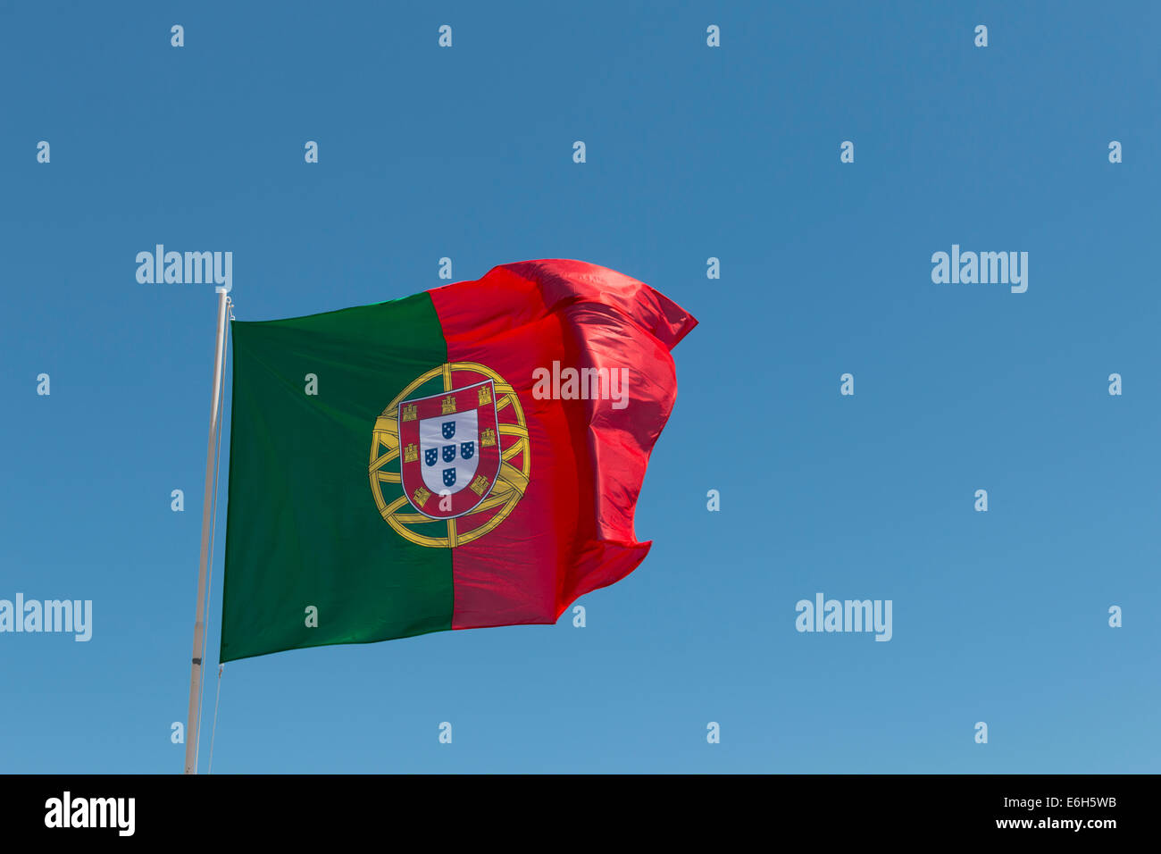 Portuguese flag over a clear blue sky Stock Photo - Alamy