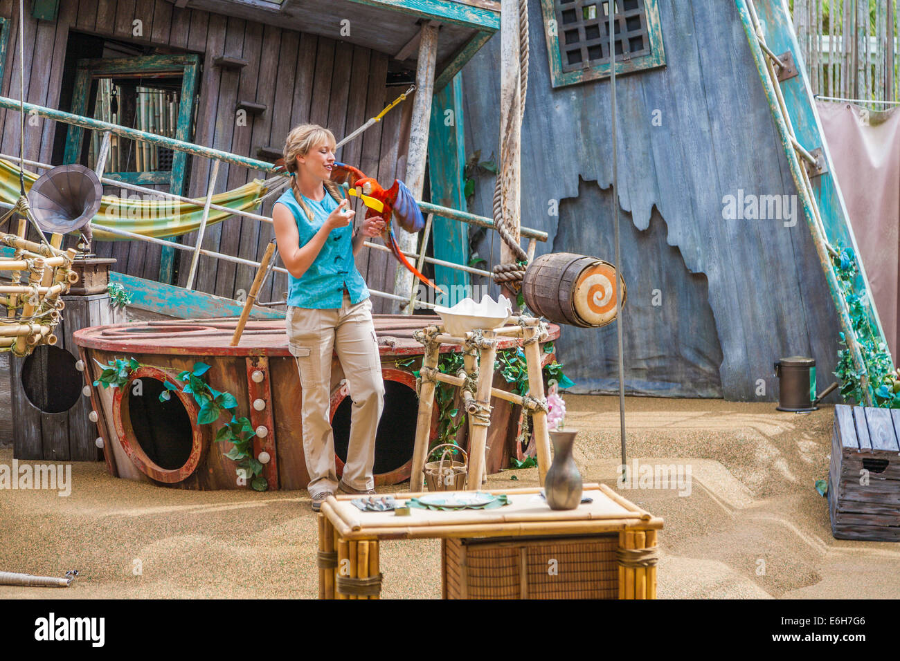 Female zoo keeper demonstrates training of scarlet macaw during animal ...