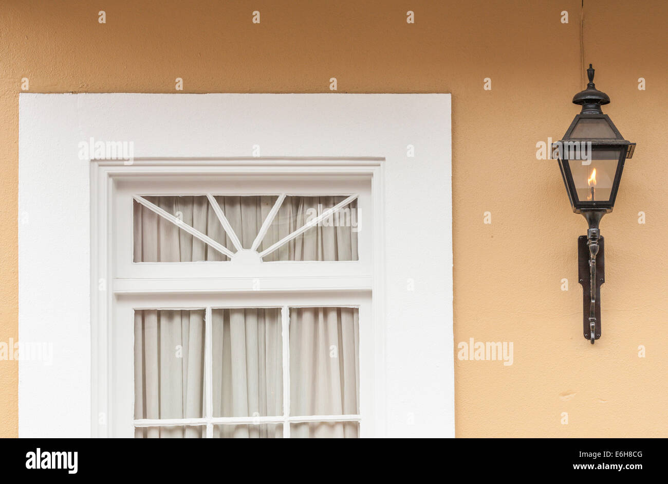 Gas light wall sconce next to window on exterior of building in the ...