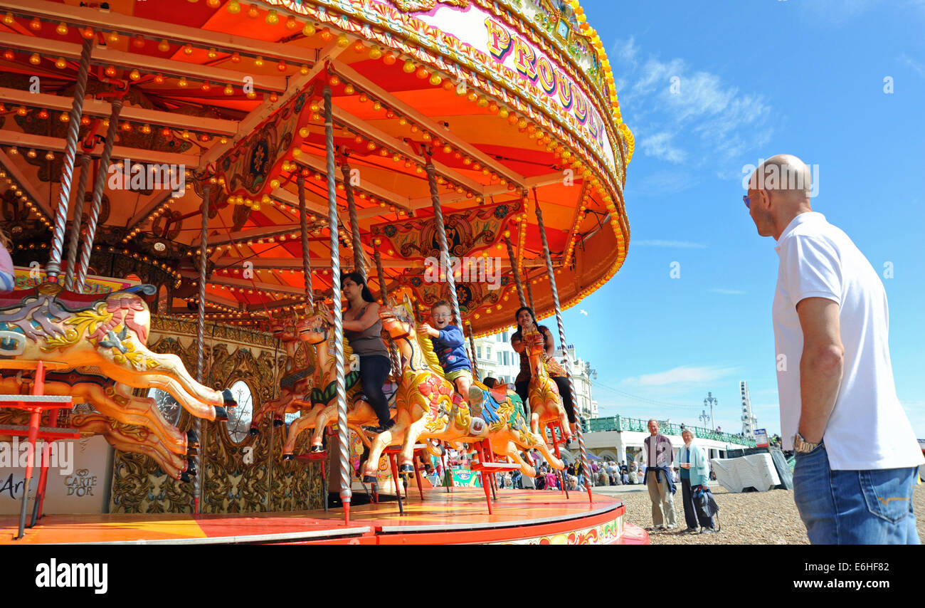 Families enjoy rides on the Brighton seafront carousel in the hot ...