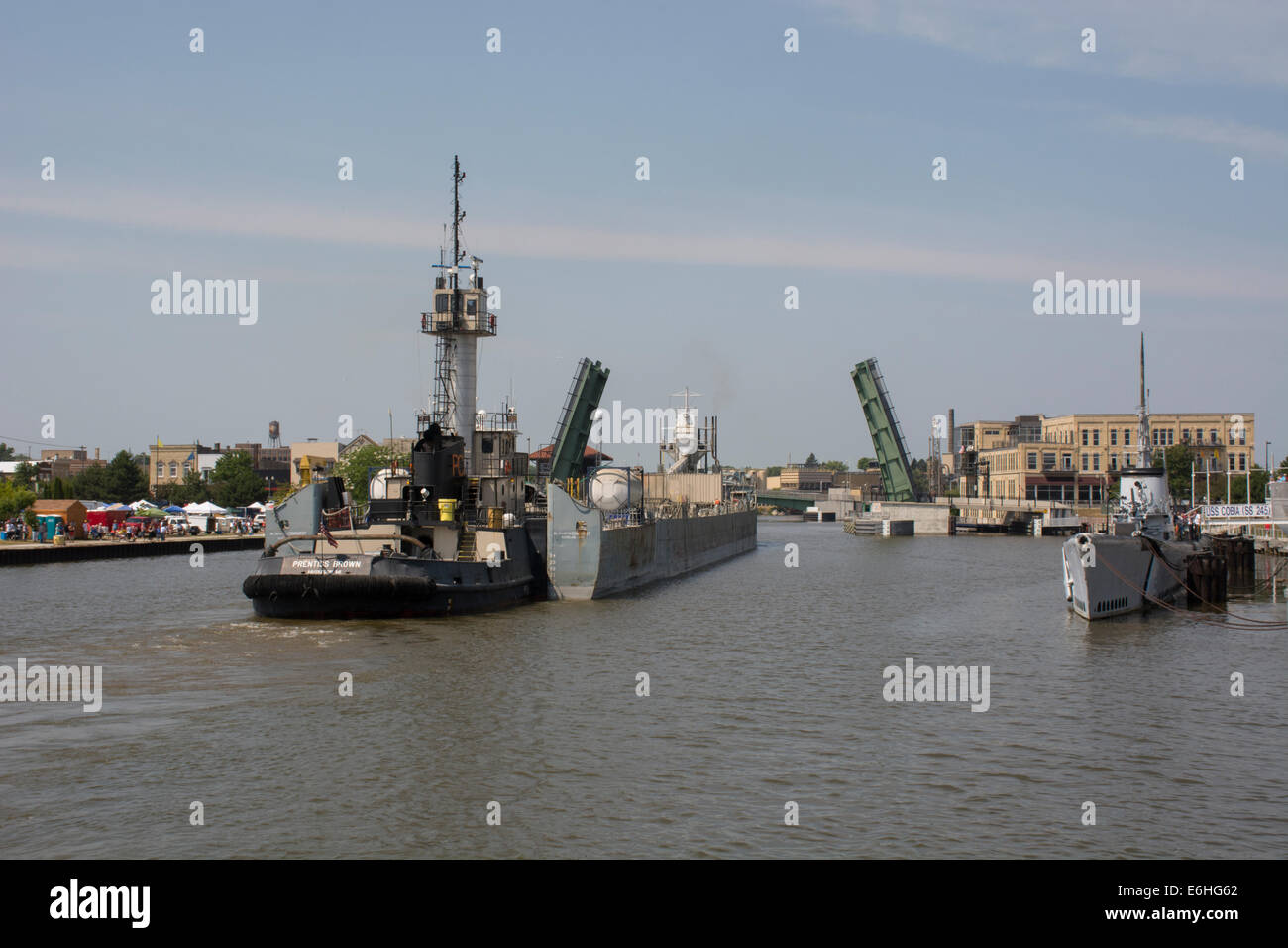 Wisconsin, Manitowoc. Manitowoc River. Tugboat pushing barge sailing up ...