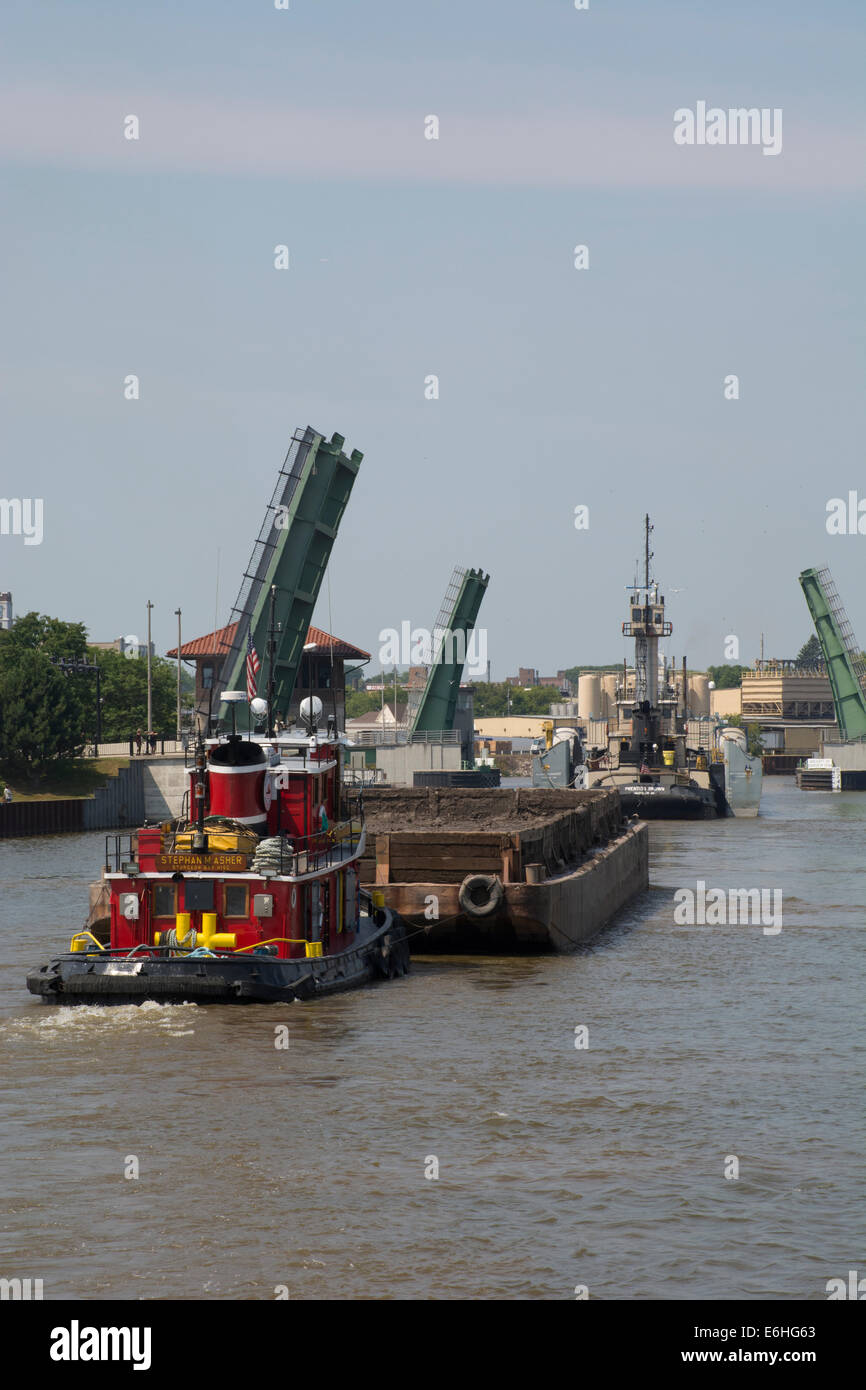 Wisconsin, Manitowoc. Manitowoc River. Tugboat and barge sailing up the ...
