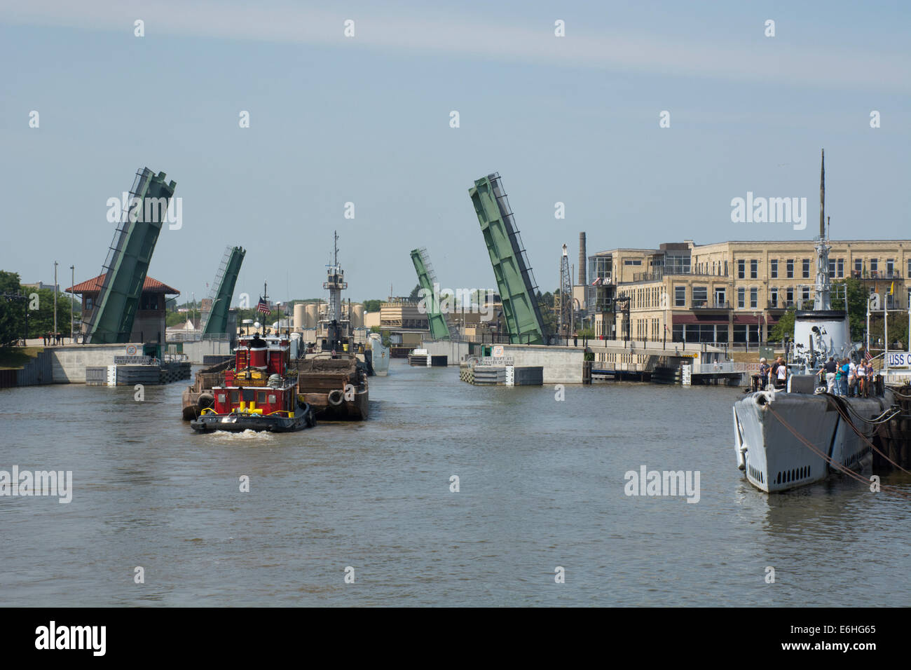 Wisconsin, Manitowoc. Manitowoc River. Tugboat and barge sailing up the ...