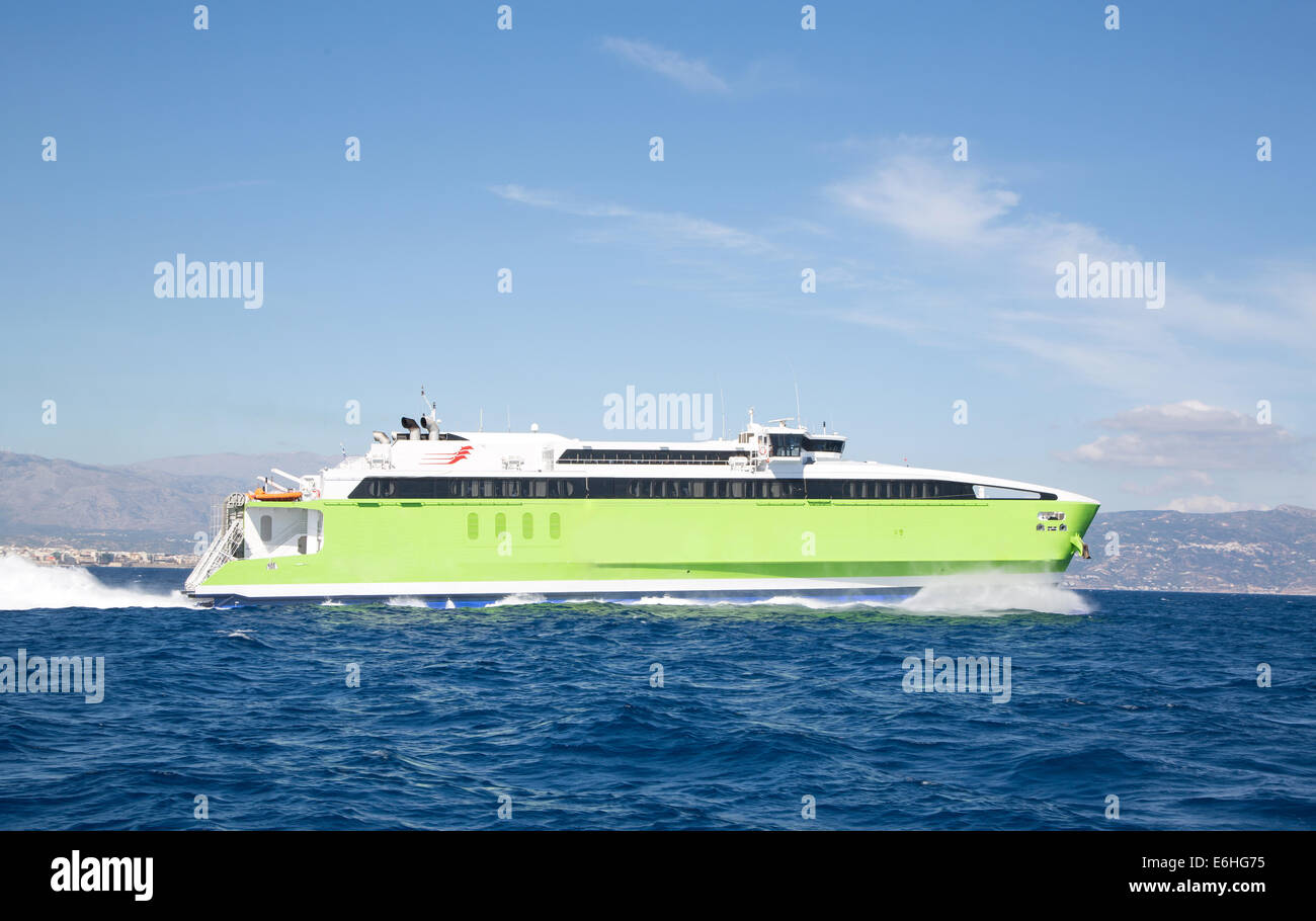 Green ferry spead boat on the greek islands with blue water background ...