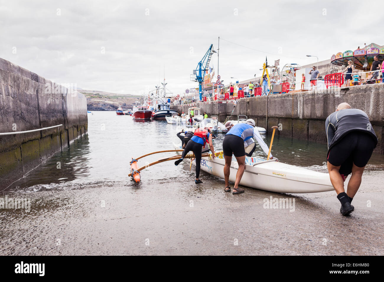 Six man rowing team launching an outrigger canoe at Playa San Juan ...
