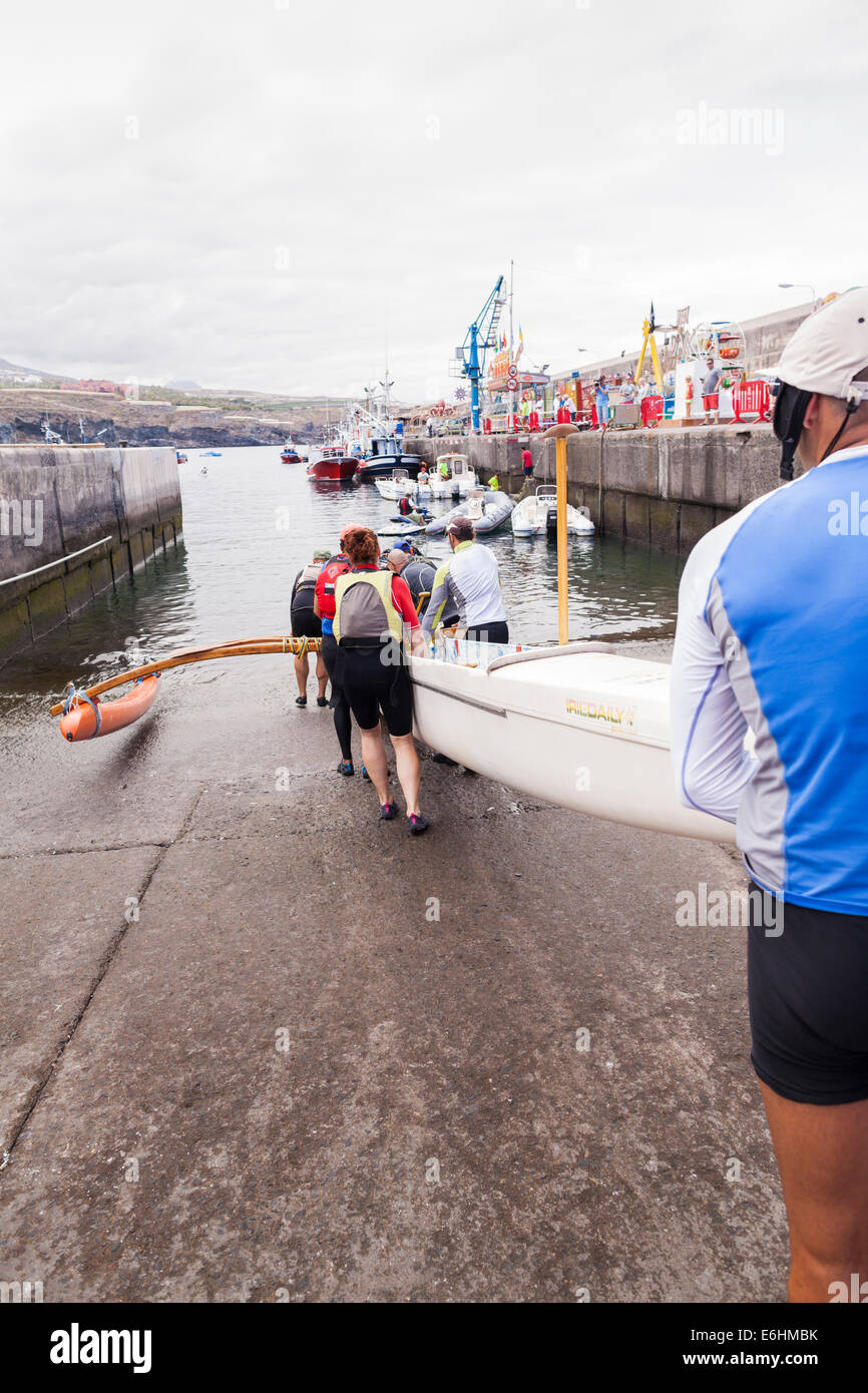 Six man rowing team launching an outrigger canoe at Playa San Juan ...