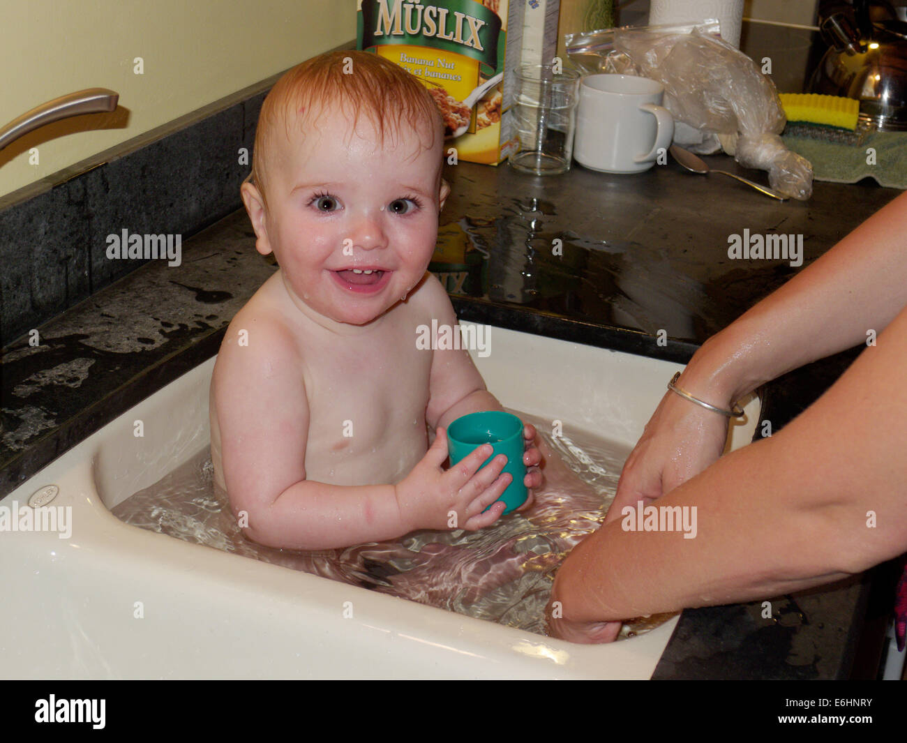 A smiling baby being washed in the sink Stock Photo - Alamy