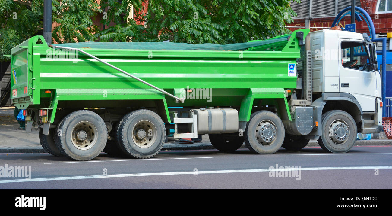 Side view unmarked clean green hgv tipper lorry truck & driver with ...