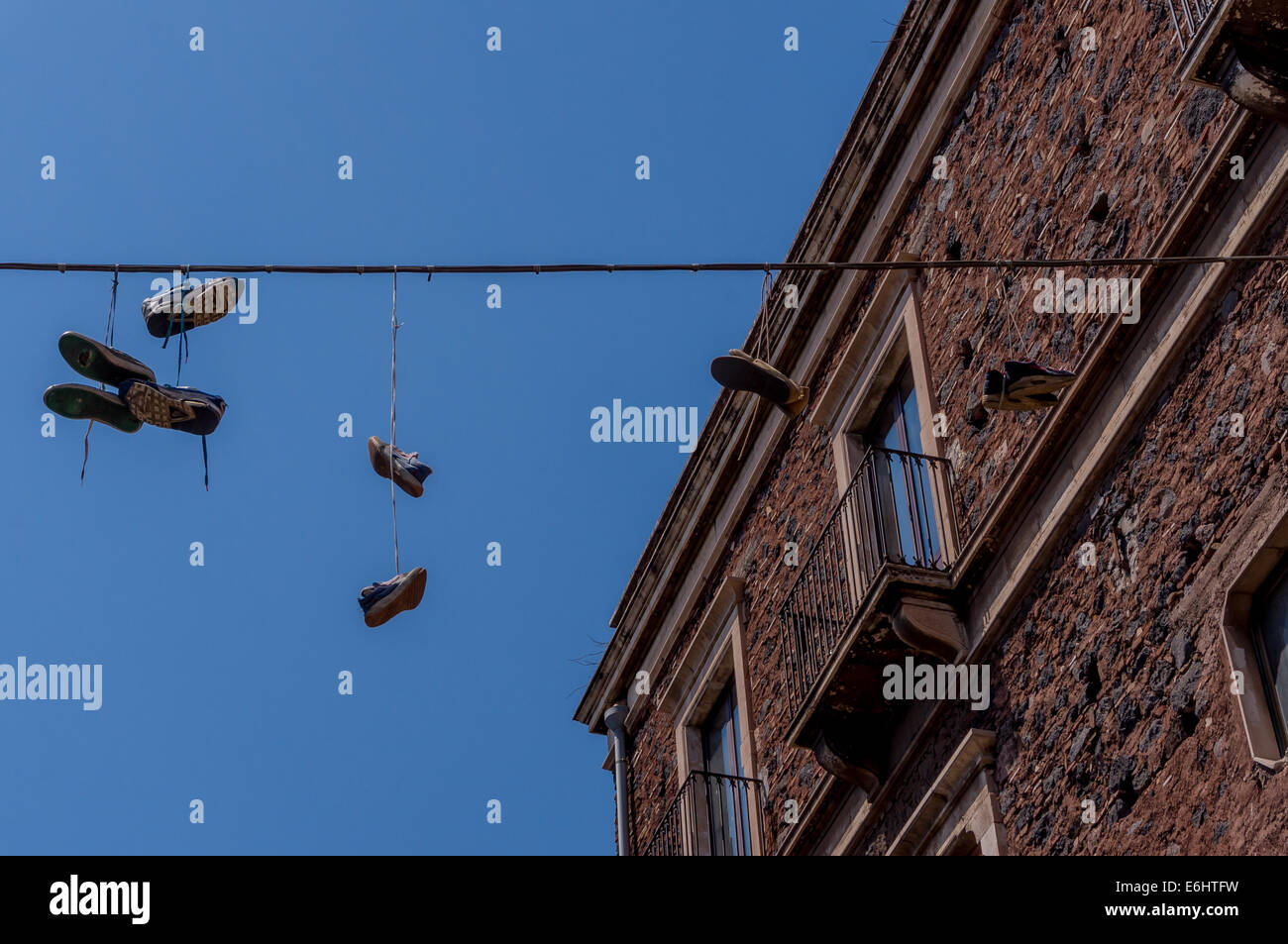 Pairs of shoes hanging from overhead wire. Shoefiti Stock Photo - Alamy