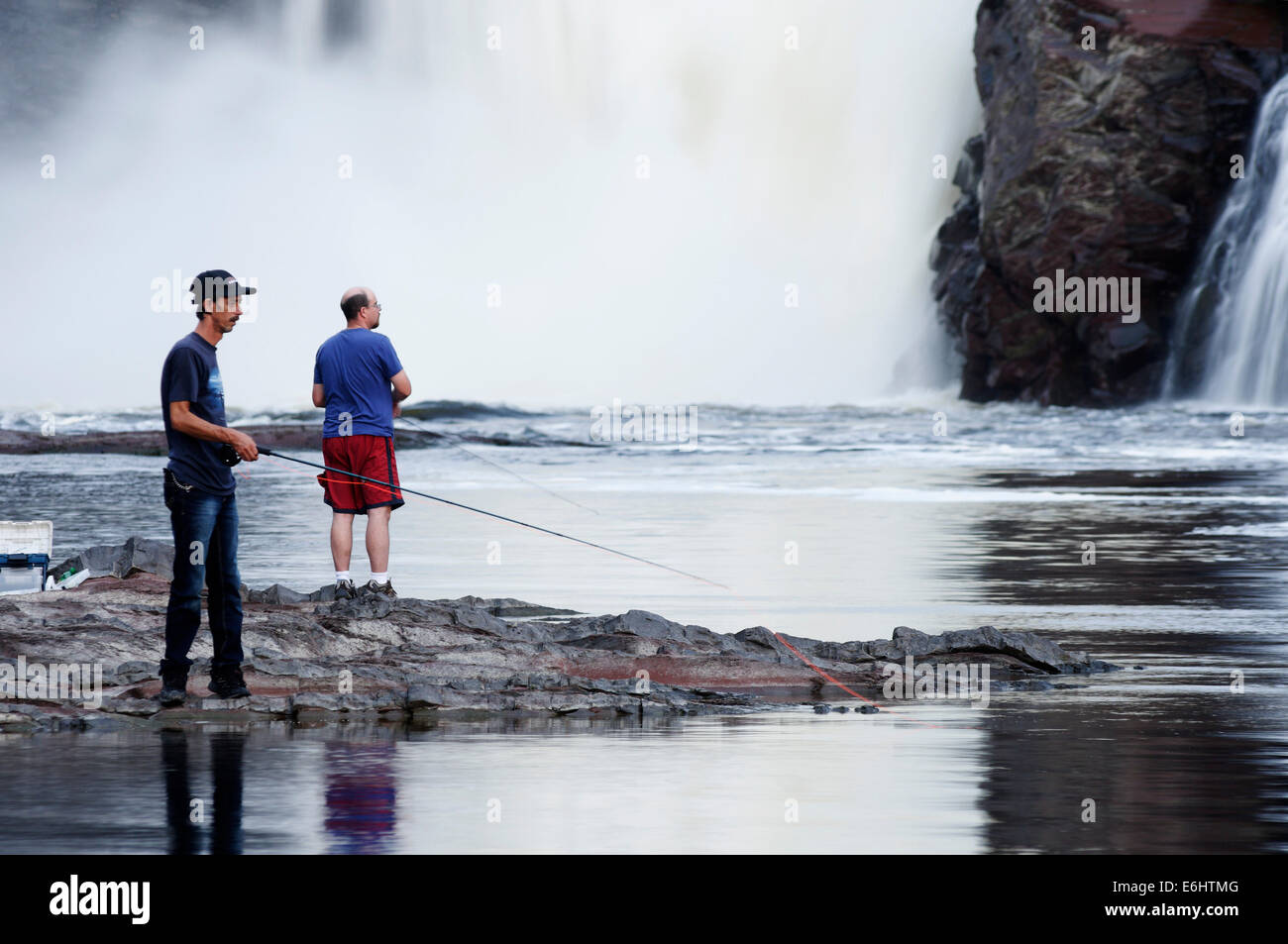 Two men fishing at Chute de la Chaudiere waterfall near Quebec City ...