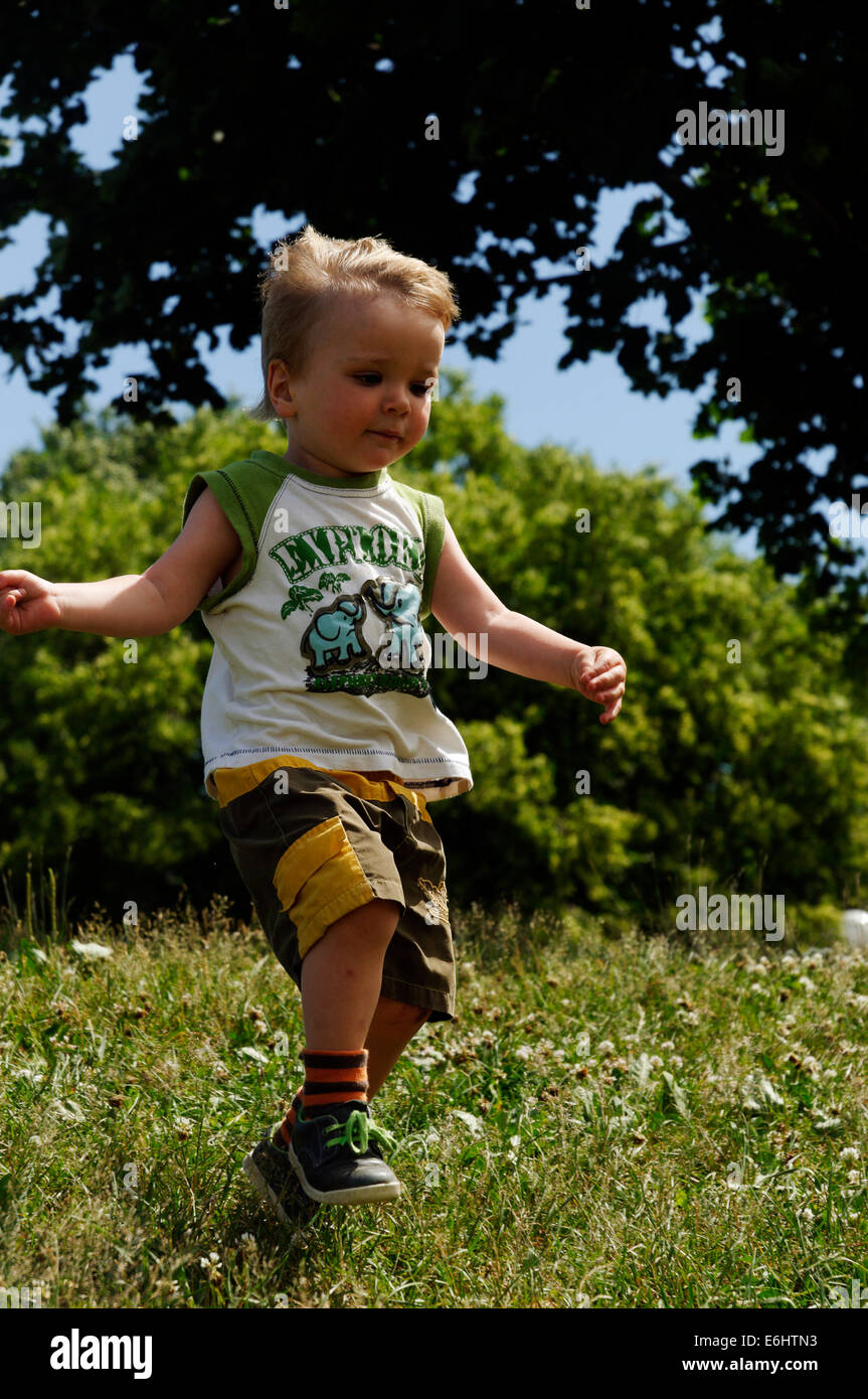 A young boy running down a grassy slope Stock Photo - Alamy