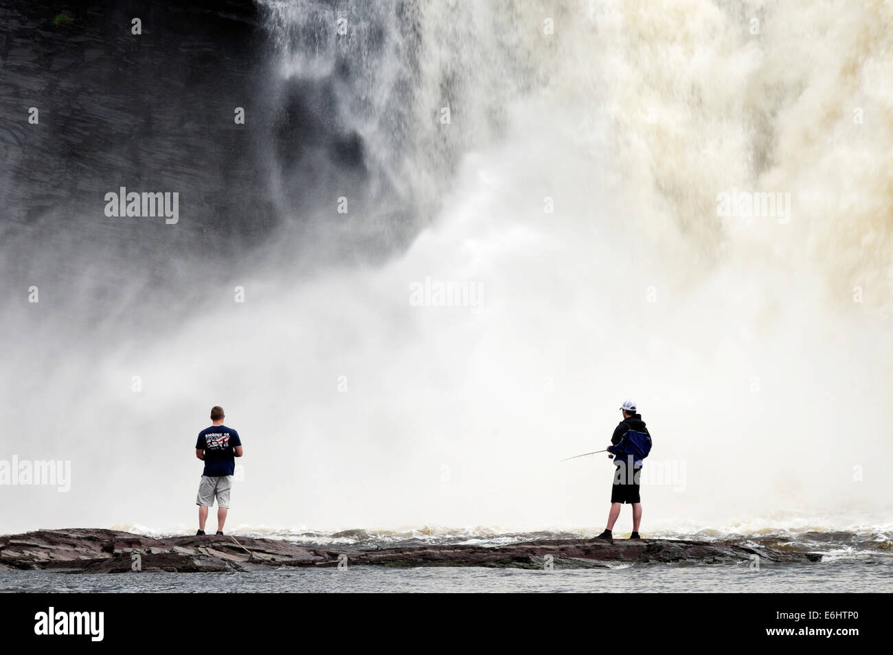 Two wild fishermen fishing with the Chute de la Chaudiere waterfall ...