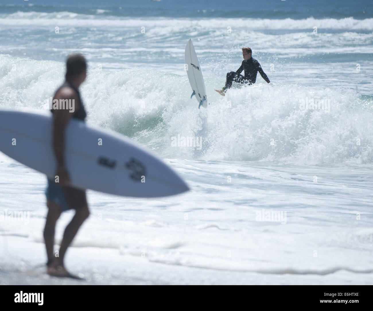 Young surfer coming out of the water on the beach hi-res stock ...