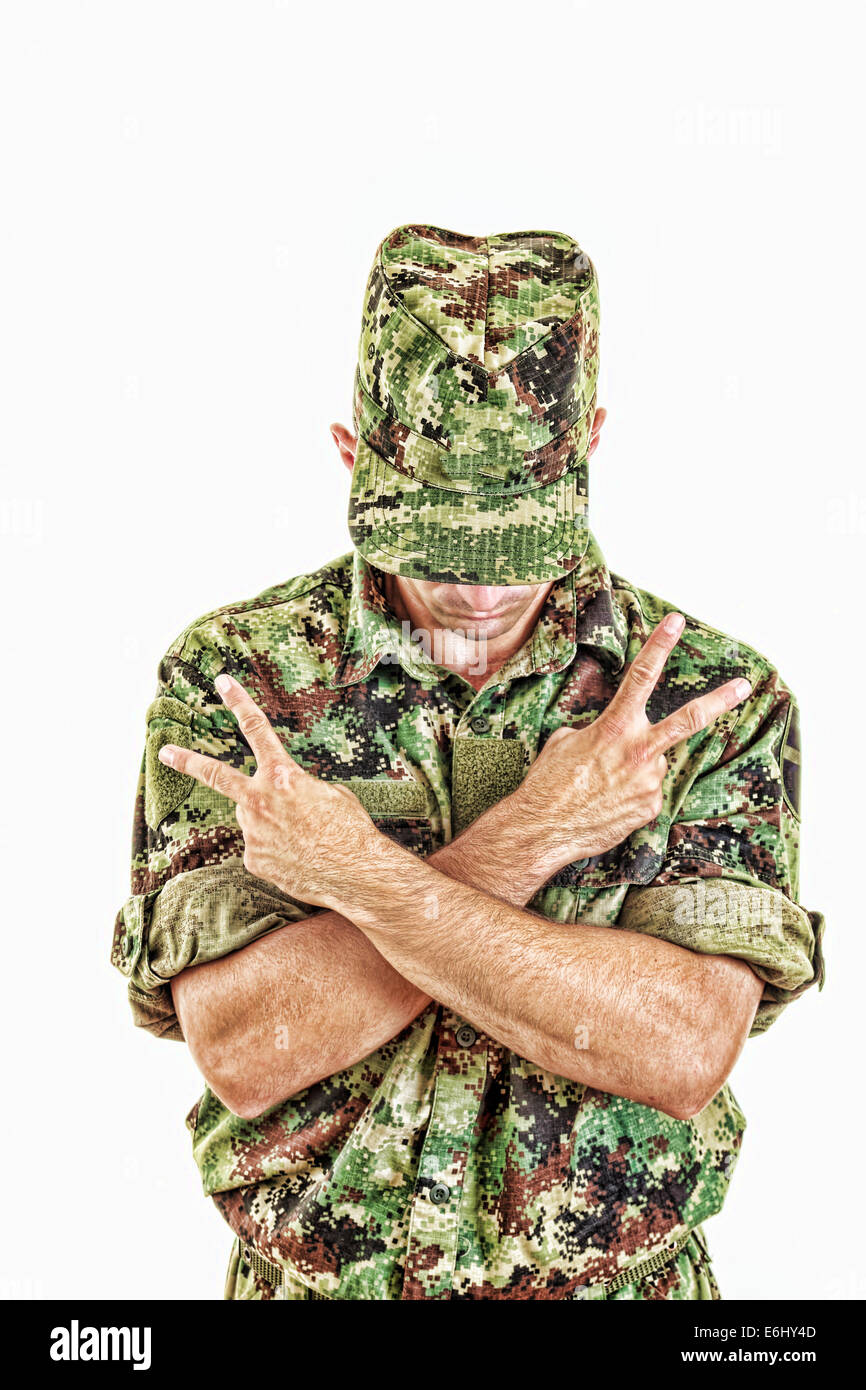 unknown soldier with hidden face in green camouflage uniform covers ...